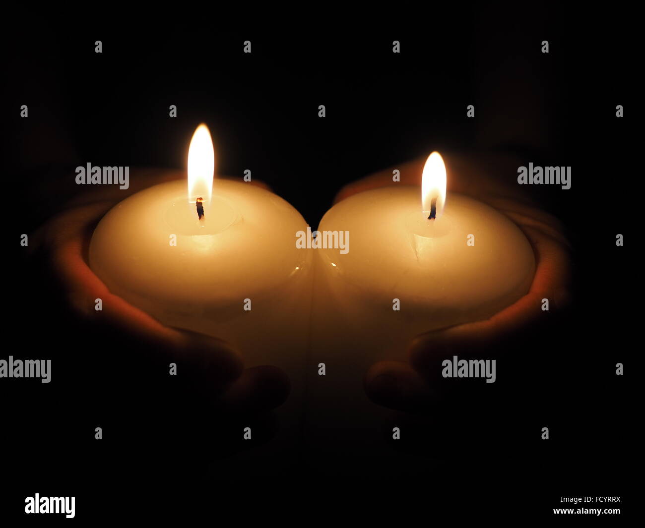 candle and hands on a black background Stock Photo - Alamy