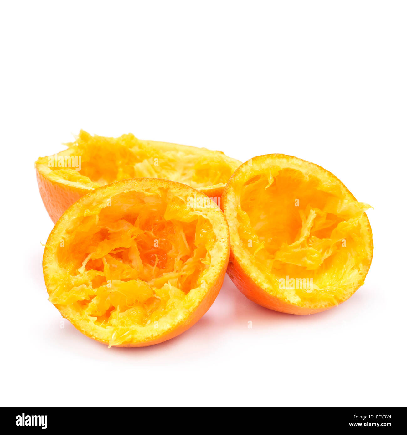 some oranges cut in halves after being squeezed on a white background ...