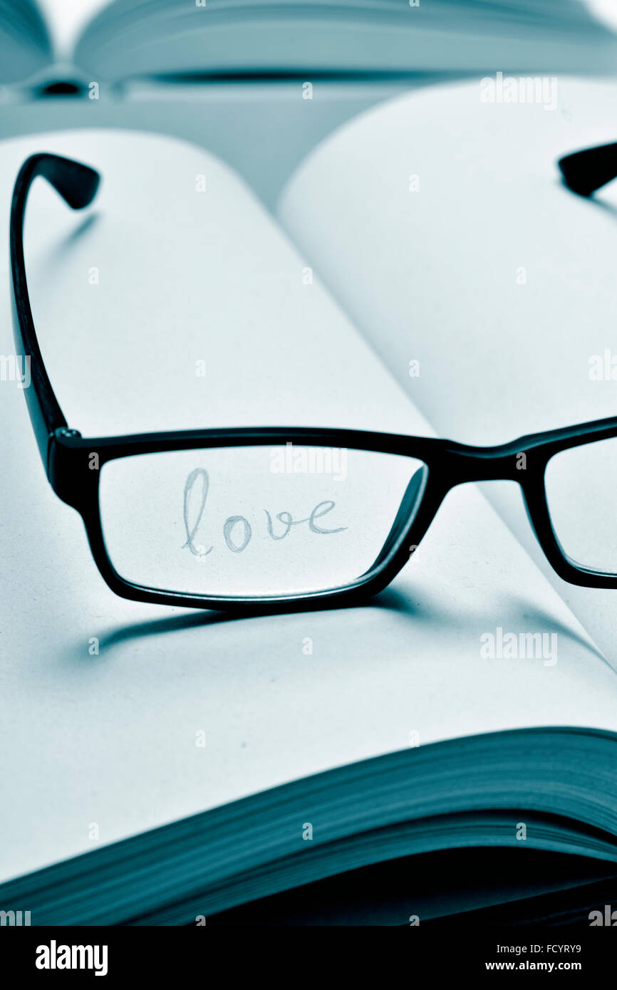 the word love handwritten in a notebook seen through the lens of a ...