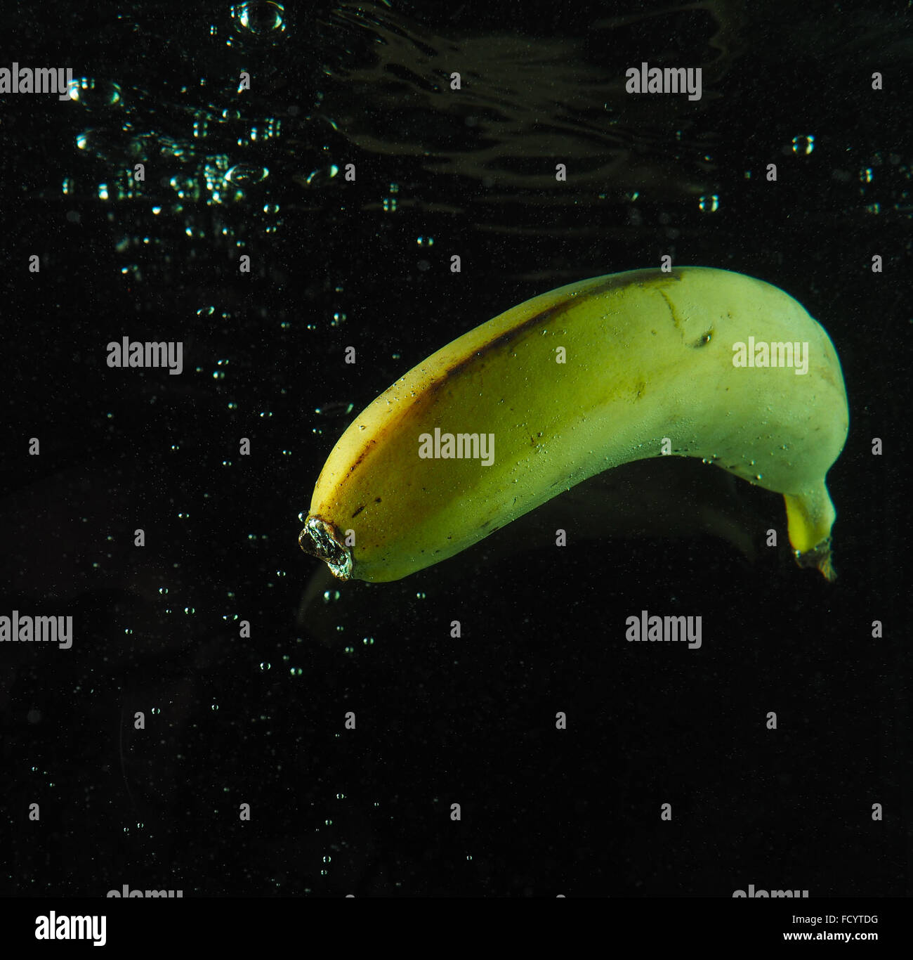 Banana in water with bubbles on a dark background Stock Photo - Alamy