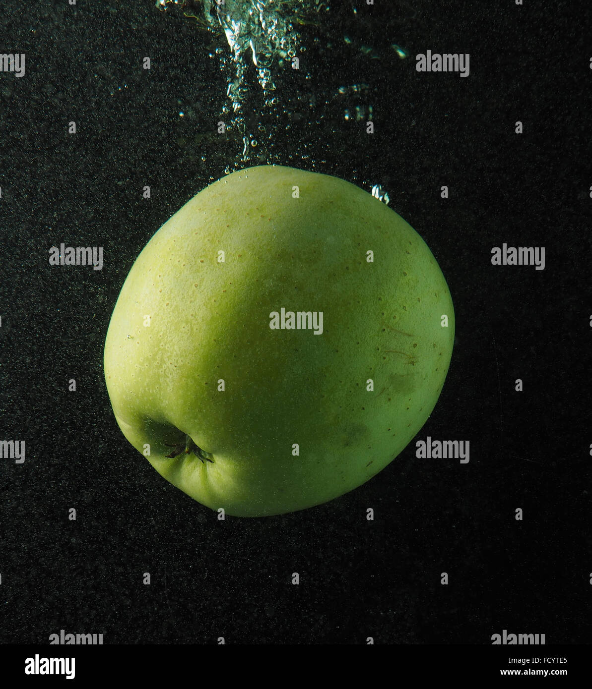 Apple in water with bubbles on a dark background Stock Photo - Alamy