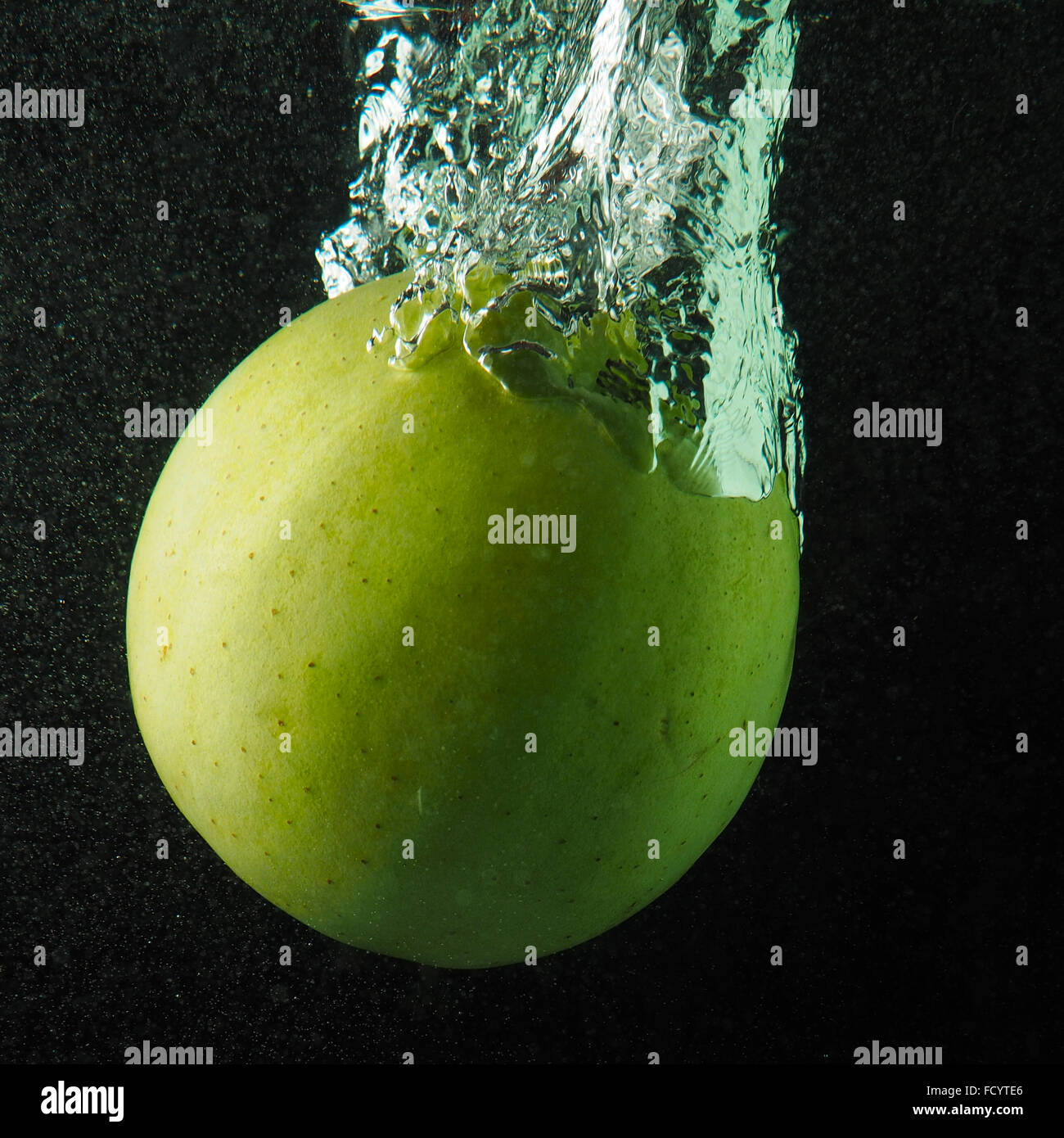 Apple in water with bubbles on a dark background Stock Photo - Alamy