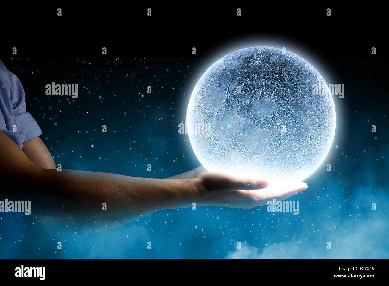 Close up of human hand holding blue glowing moon Stock Photo - Alamy
