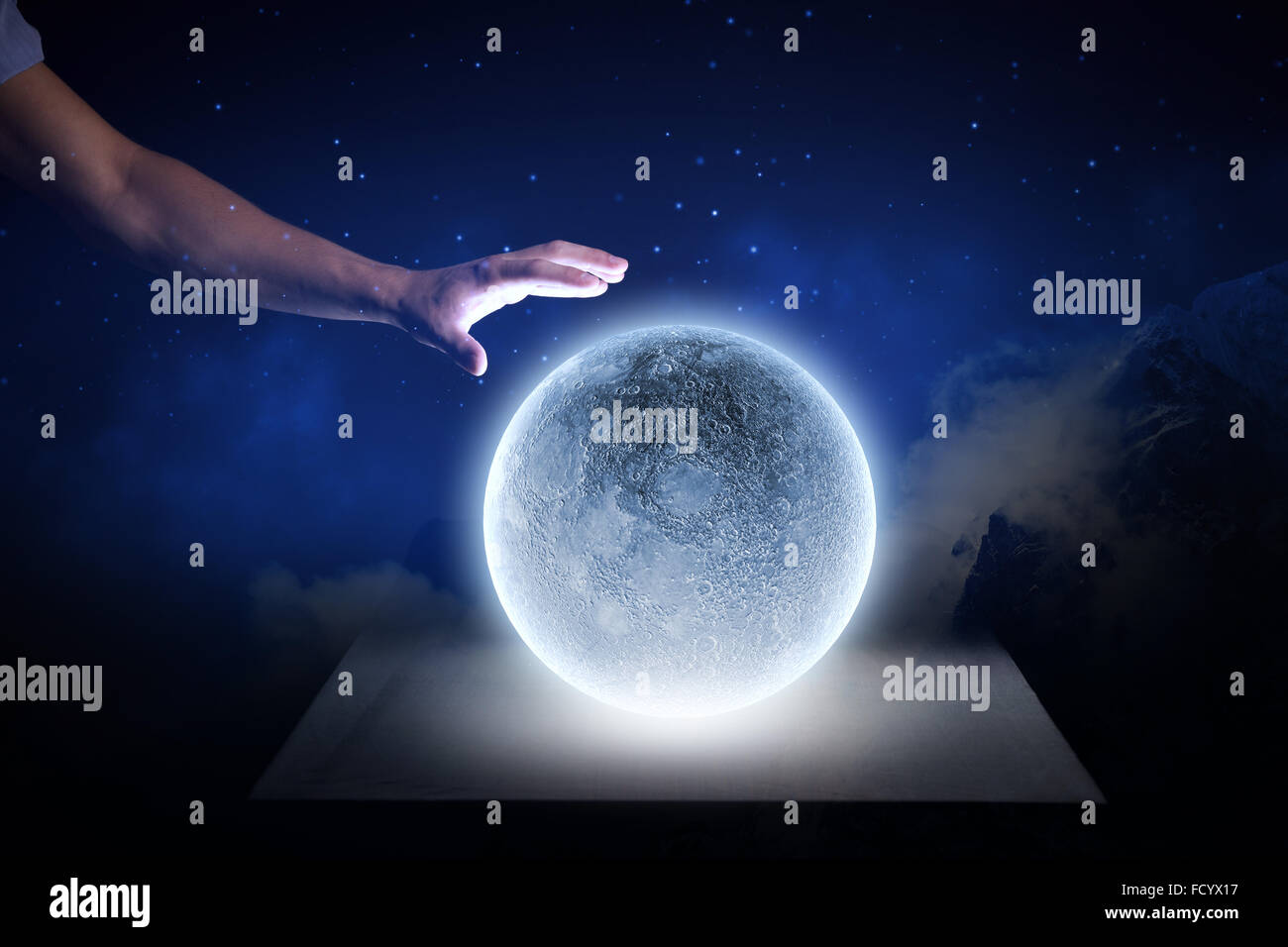 Close up of human hand touching blue glowing moon Stock Photo - Alamy