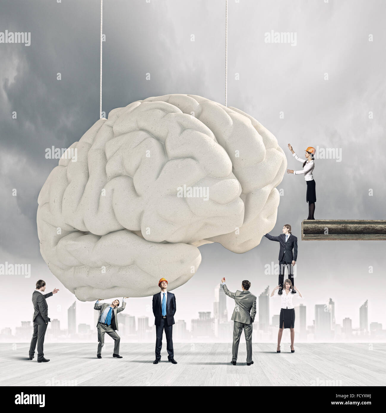 Huge human brain and many little businesspeople around Stock Photo - Alamy