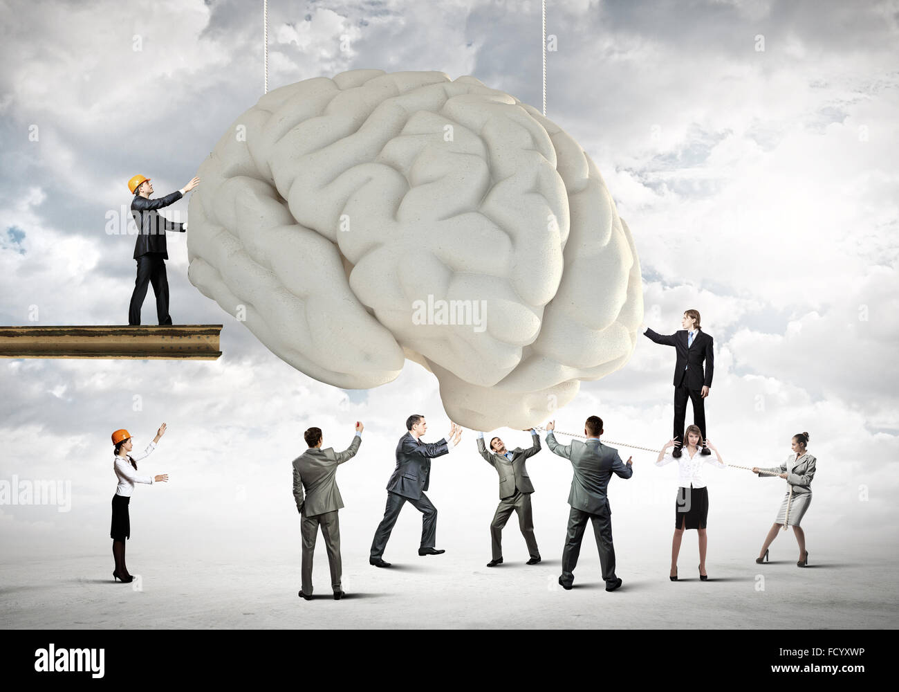 Huge human brain and many little businesspeople around Stock Photo - Alamy
