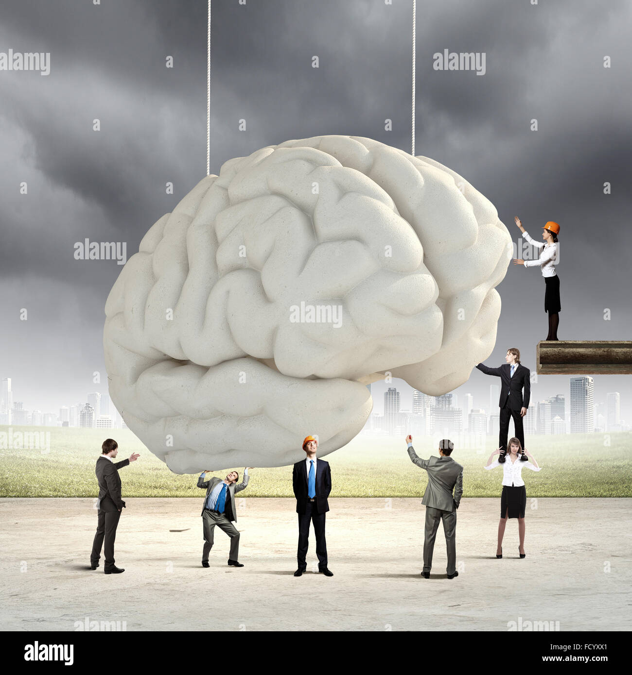 Huge human brain and many little businesspeople around Stock Photo - Alamy