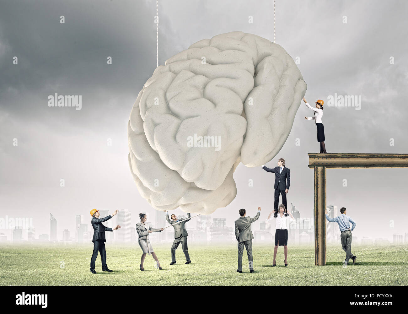 Huge human brain and many little businesspeople around Stock Photo - Alamy