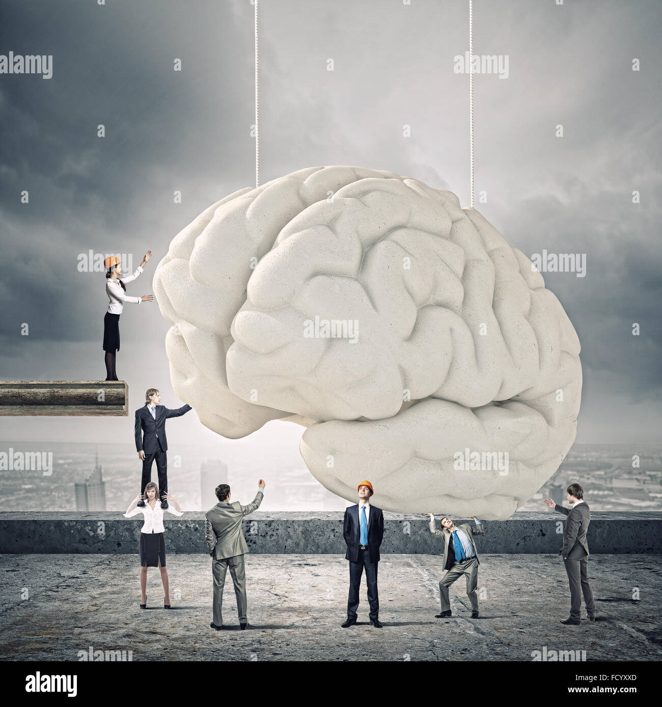 Huge human brain and many little businesspeople around Stock Photo - Alamy