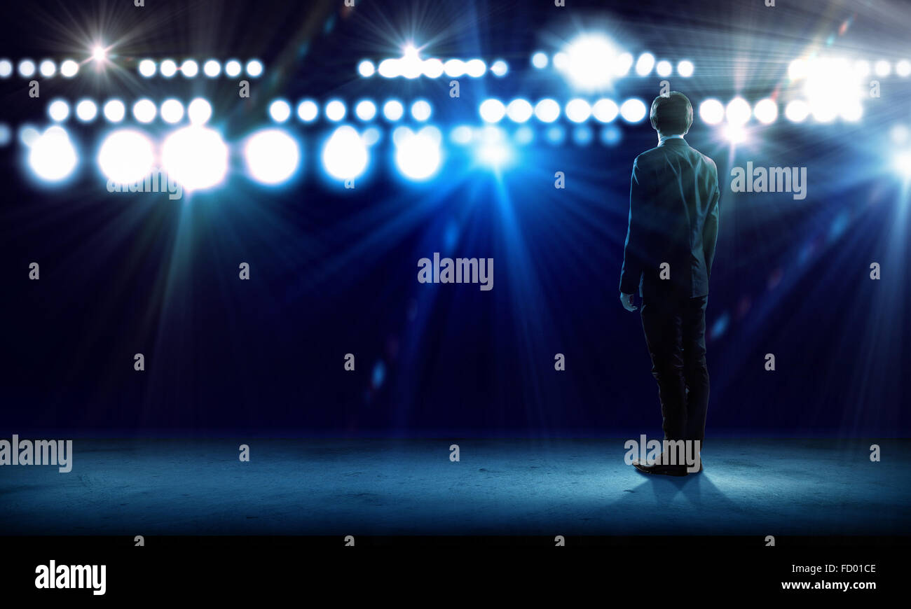 Rear view of businessman standing in lights of stage Stock Photo - Alamy