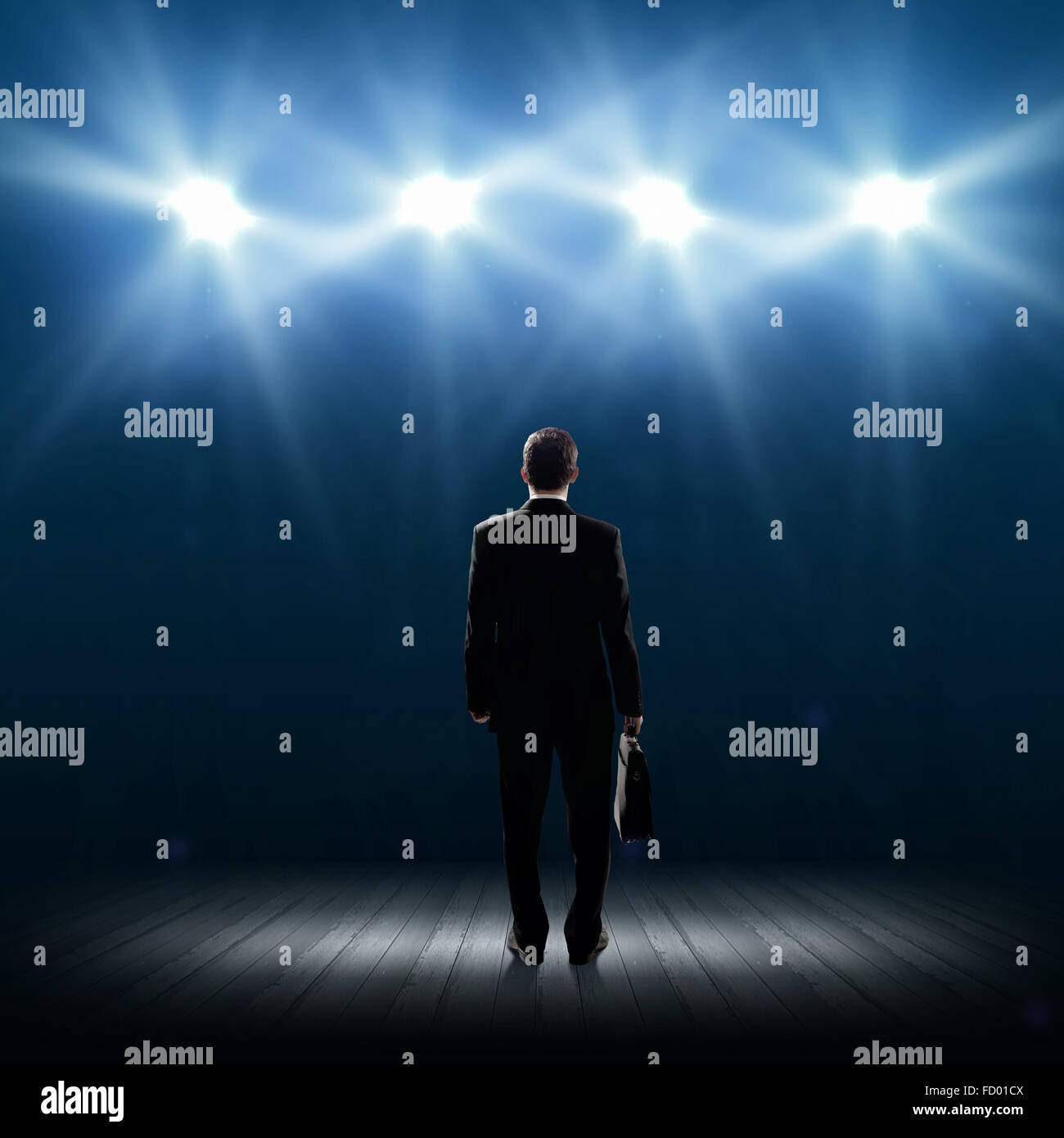 Rear view of businessman standing in lights of stage Stock Photo - Alamy