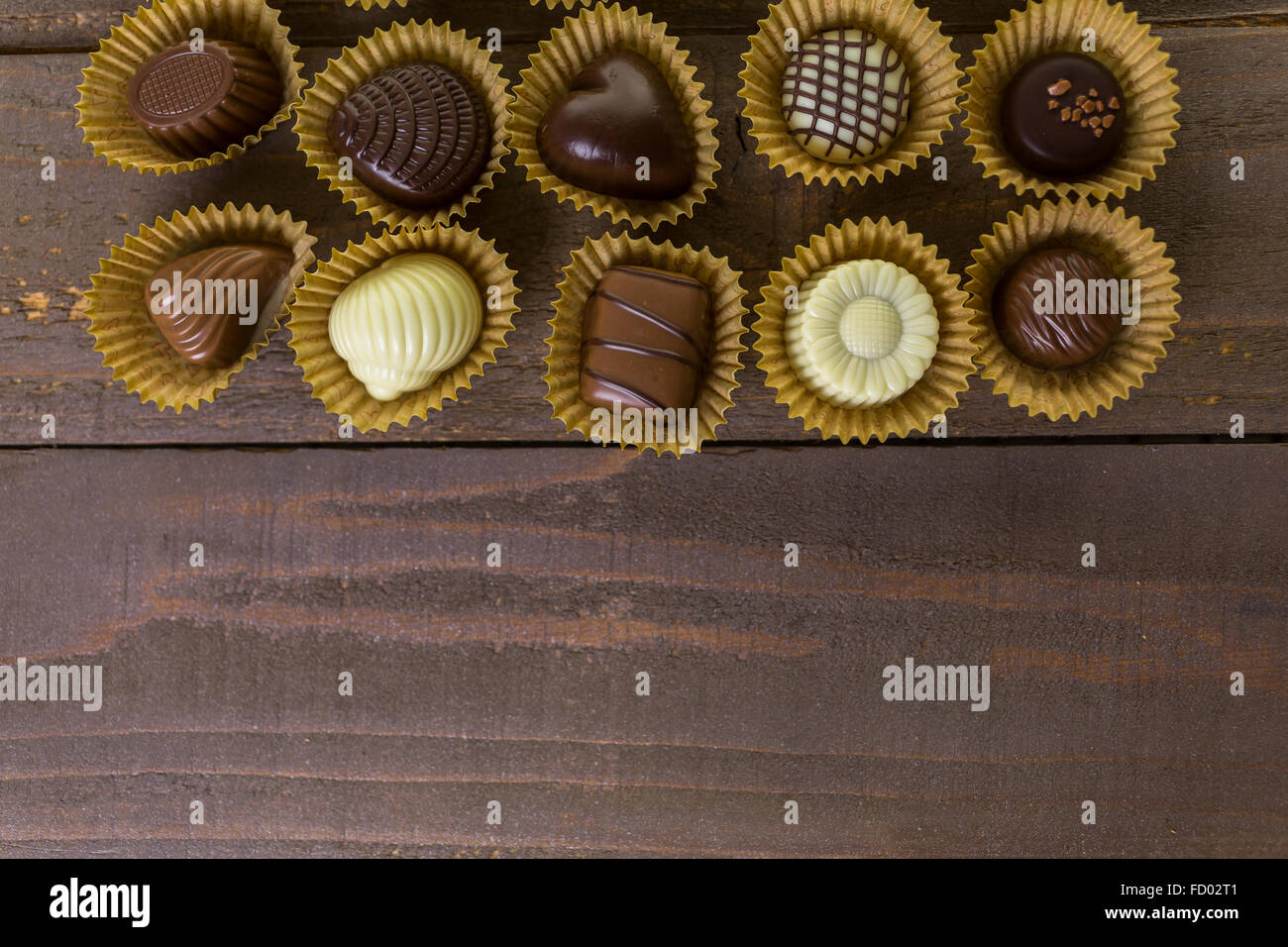 Assorted chocolated on wood table Stock Photo - Alamy