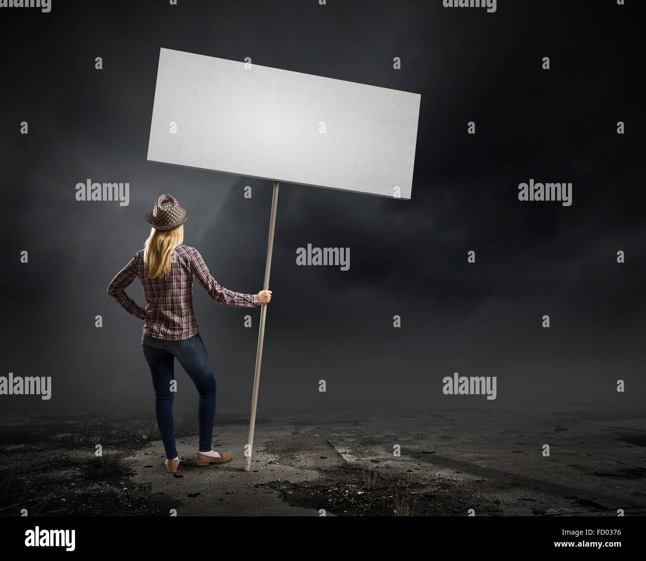 Young woman in casual carrying white blank banner Stock Photo - Alamy