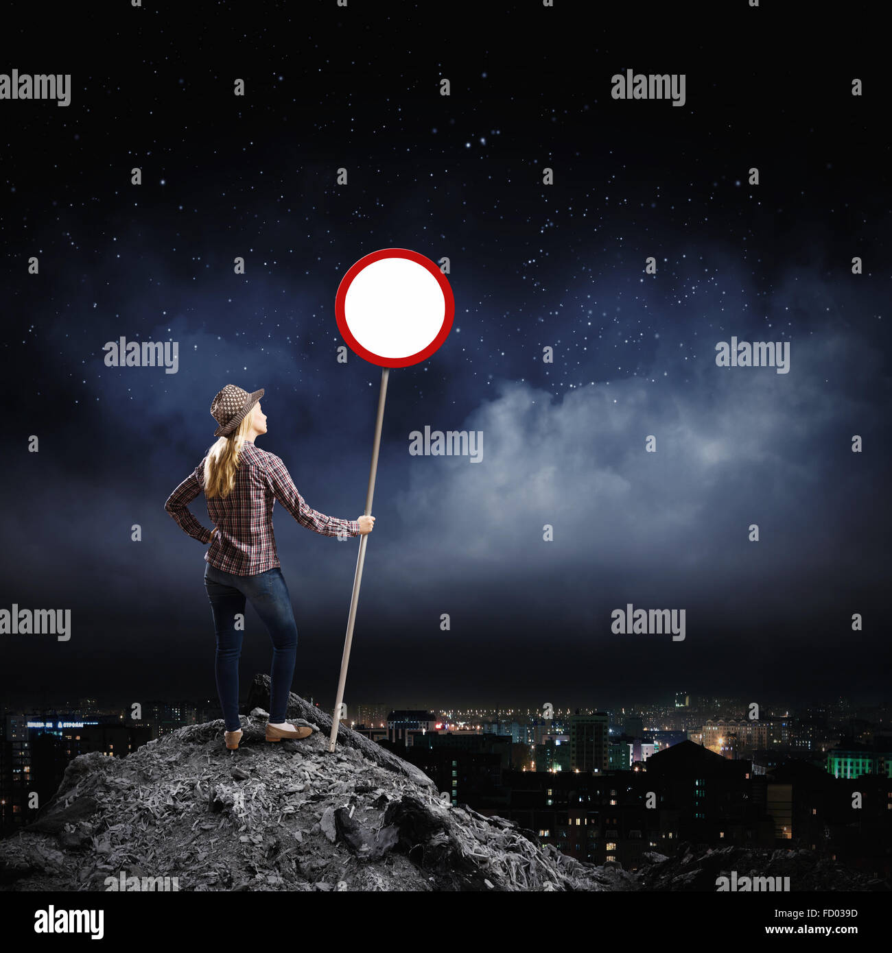 Young woman in casual holding road sign Stock Photo - Alamy