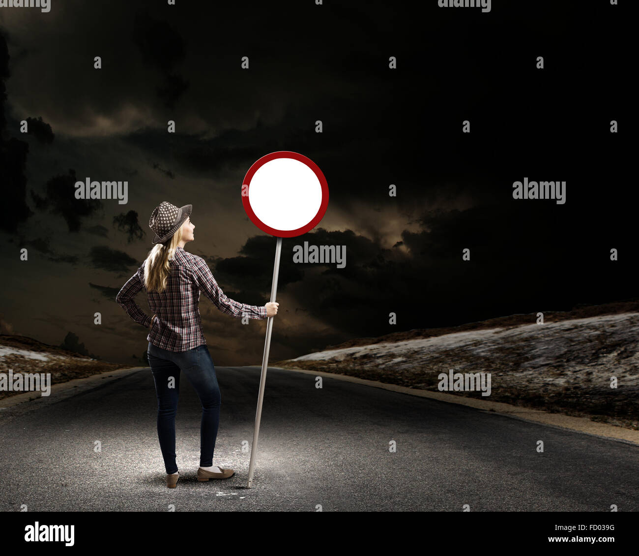 Young woman in casual holding road sign Stock Photo - Alamy
