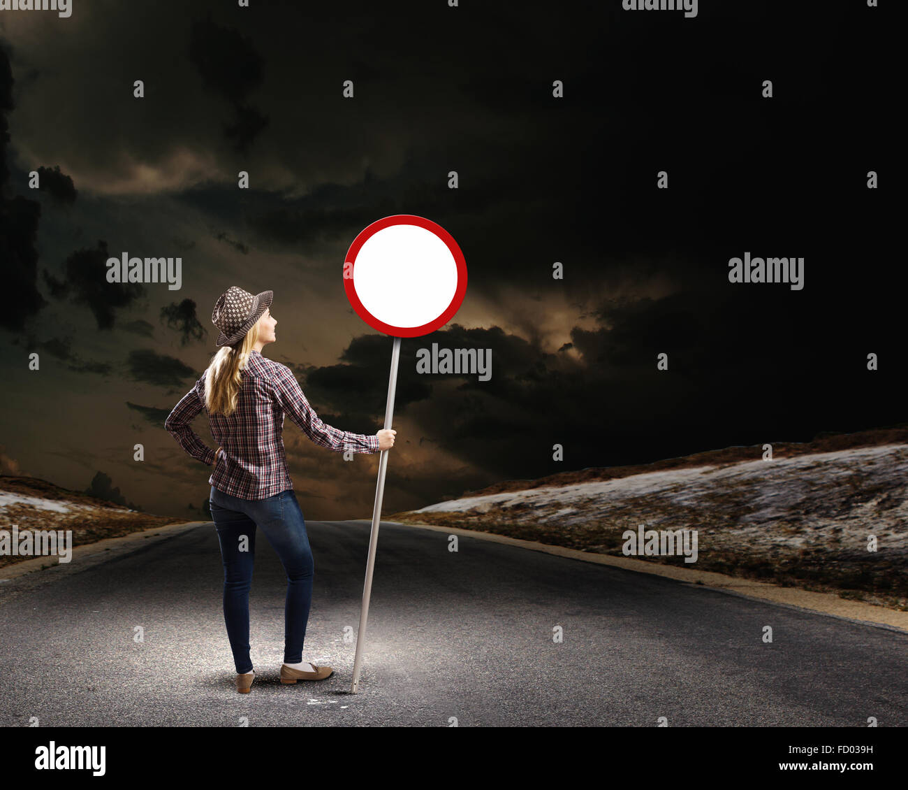 Young woman in casual holding road sign Stock Photo - Alamy