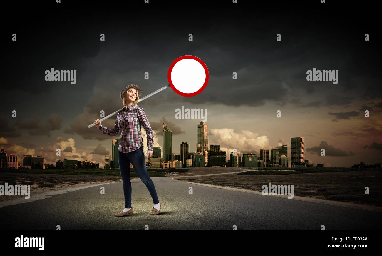 Young woman in casual holding road sign Stock Photo - Alamy