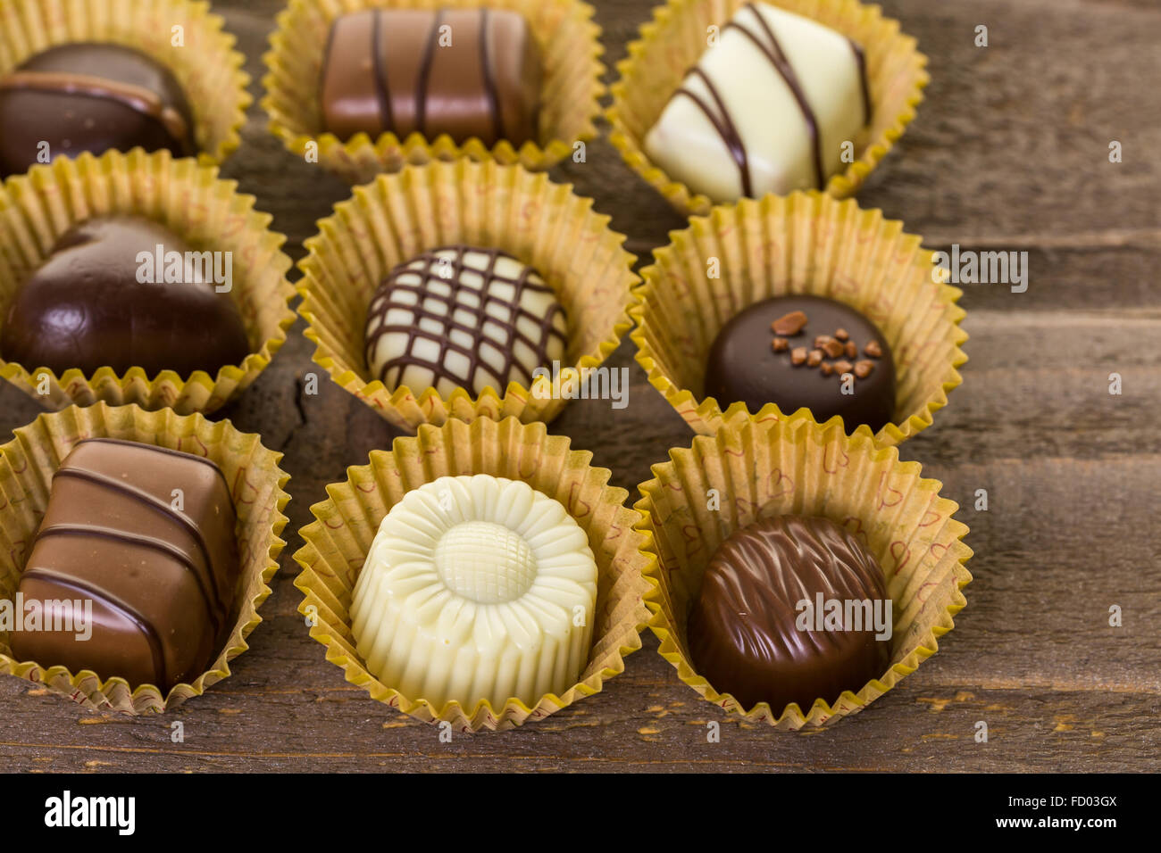 Assorted chocolated on wood table Stock Photo - Alamy