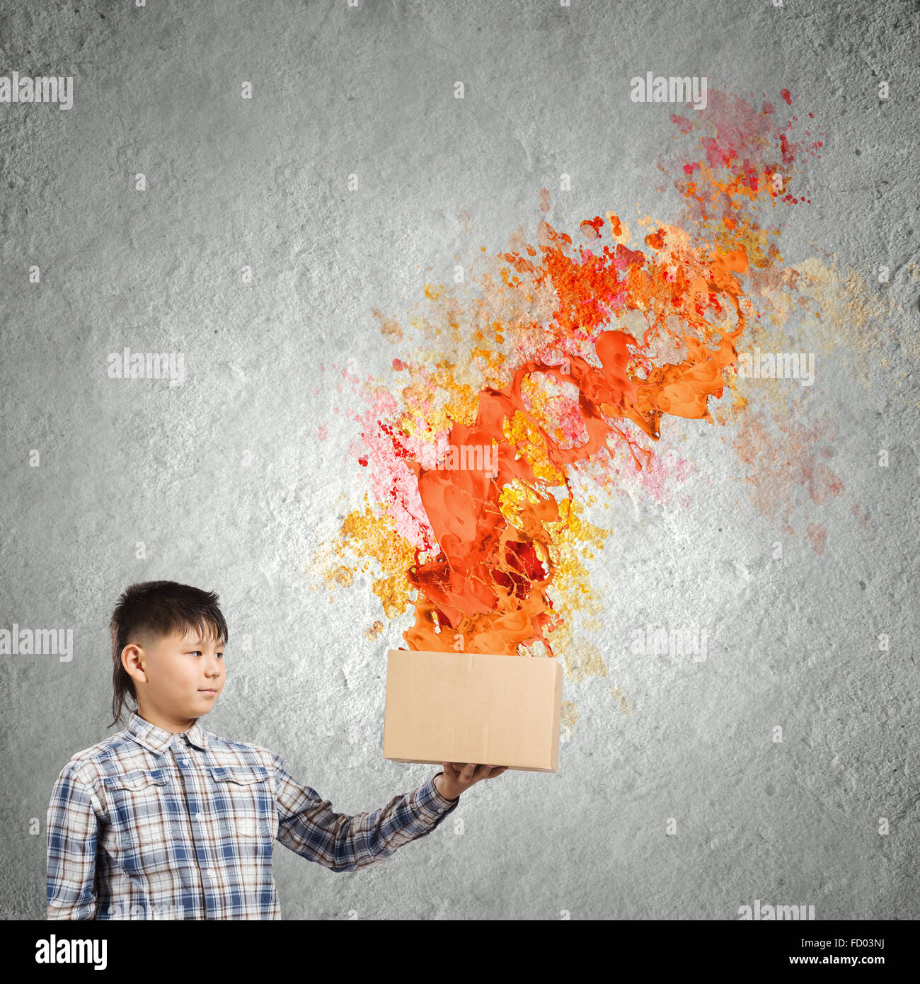 Cute boy splashing colorful paint from carton box Stock Photo - Alamy