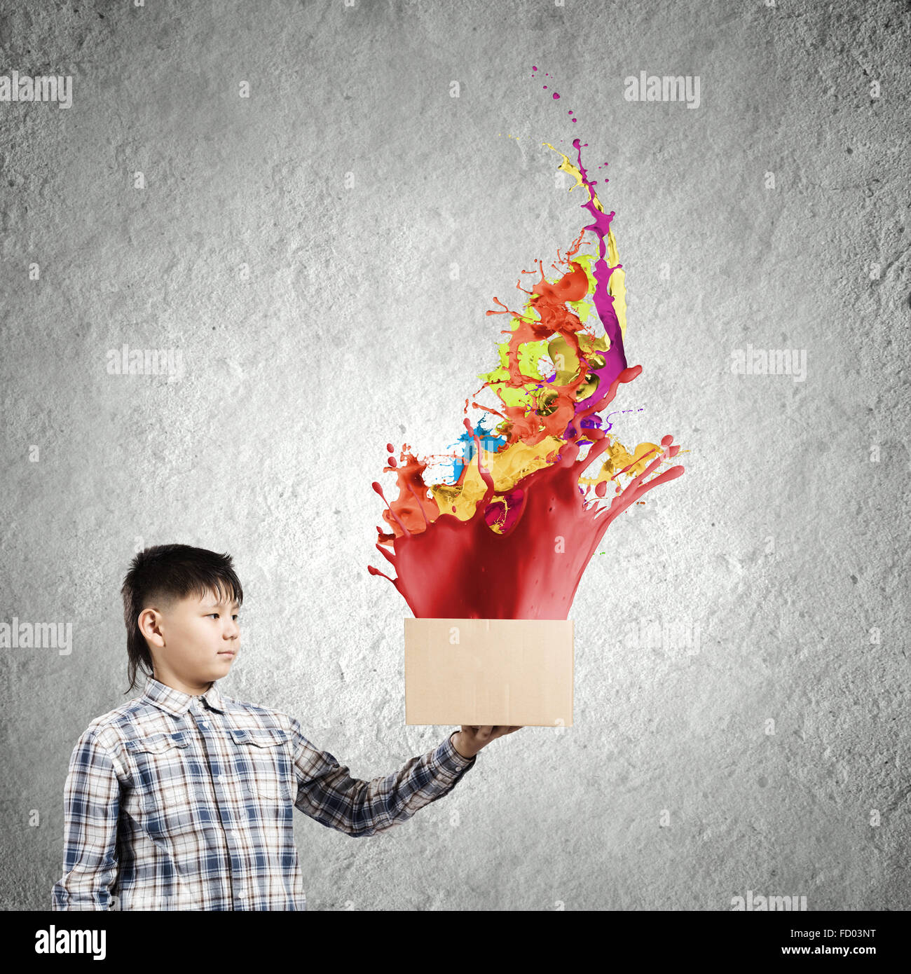 Cute boy splashing colorful paint from carton box Stock Photo - Alamy