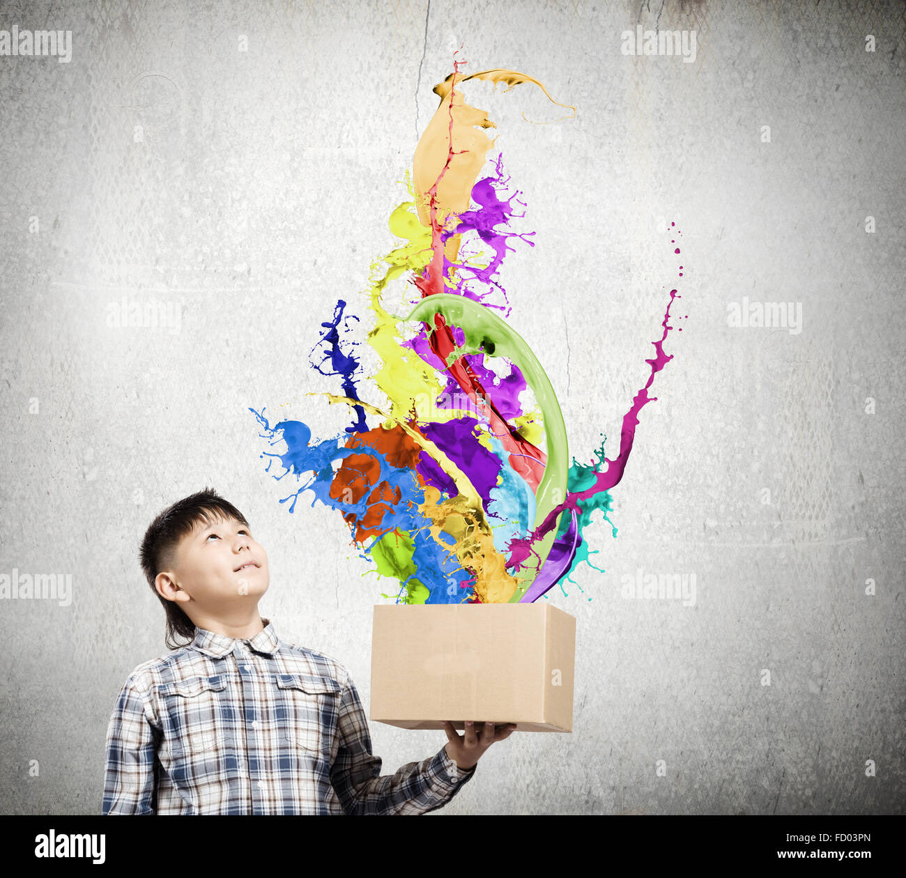 Cute boy splashing colorful paint from carton box Stock Photo - Alamy