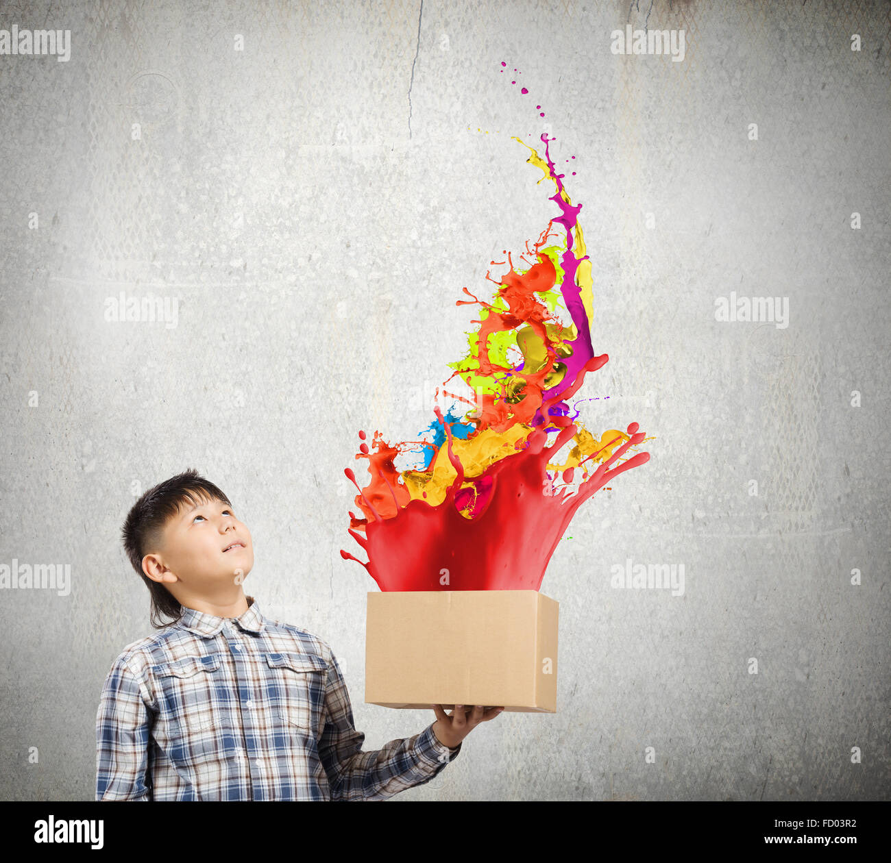 Cute boy splashing colorful paint from carton box Stock Photo - Alamy