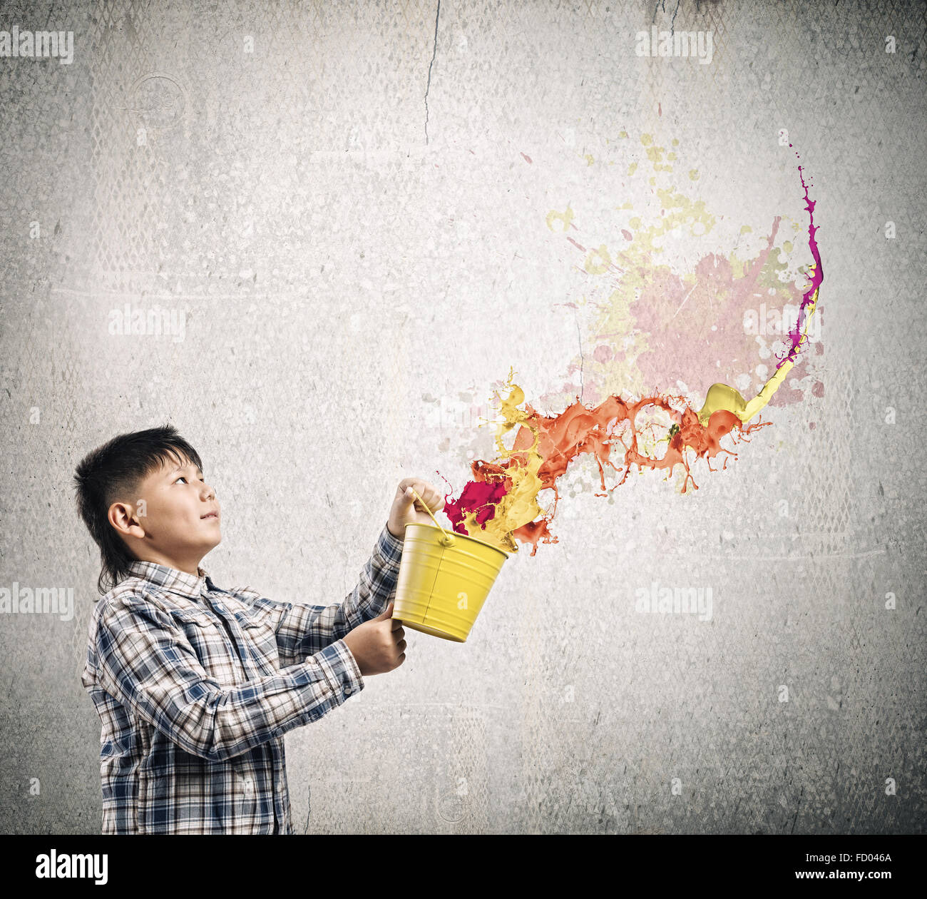 Cute boy splashing colorful paint from bucket Stock Photo - Alamy