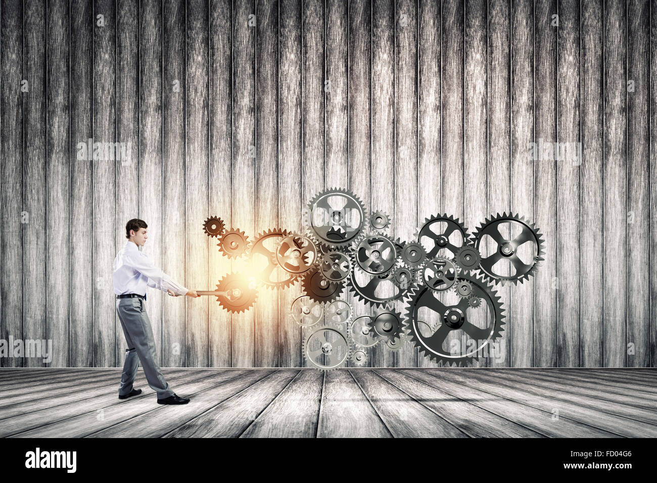 Young businessman fixing gears mechanism with wrench Stock Photo - Alamy