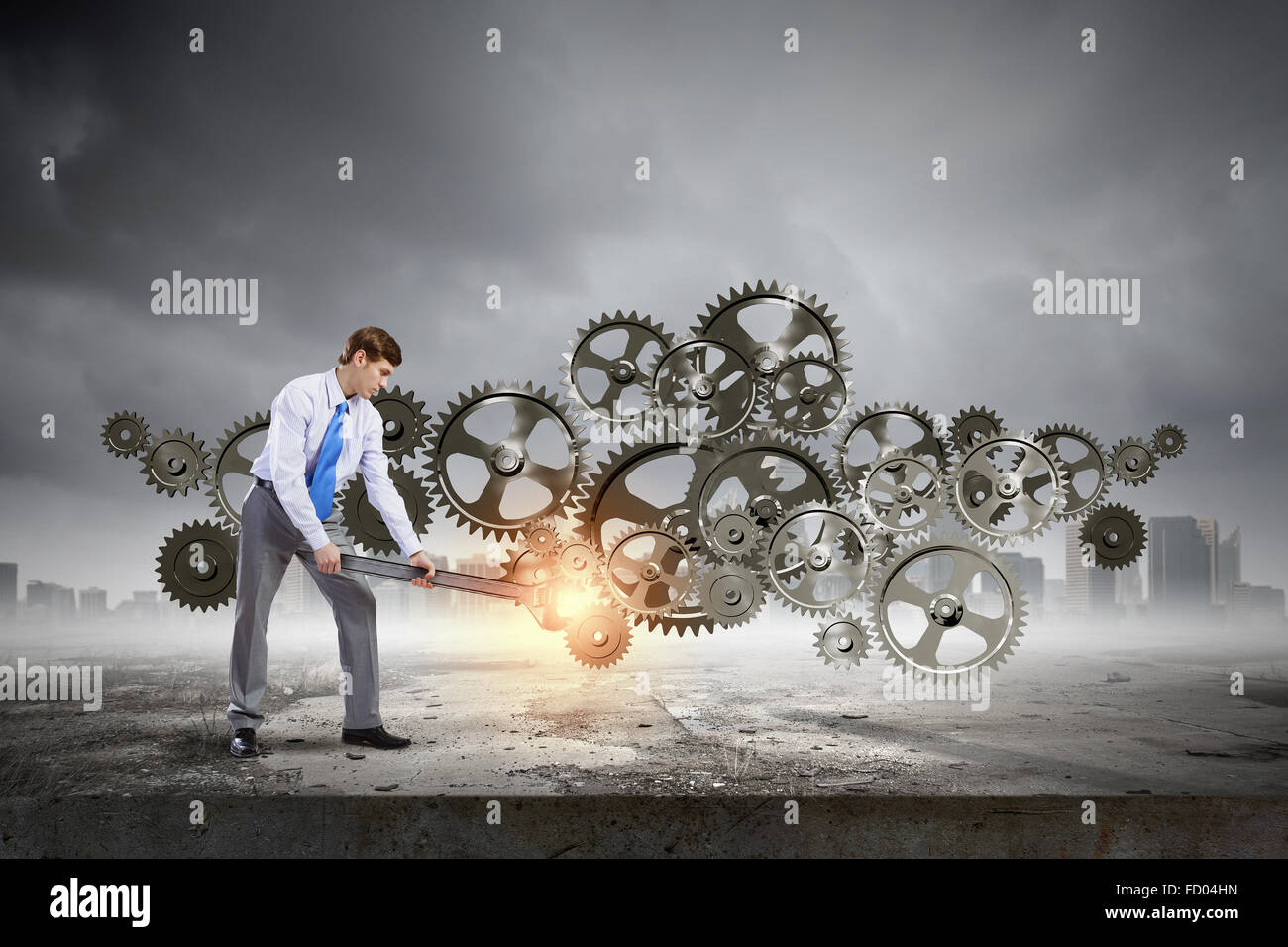 Young businessman fixing gears mechanism with wrench Stock Photo - Alamy