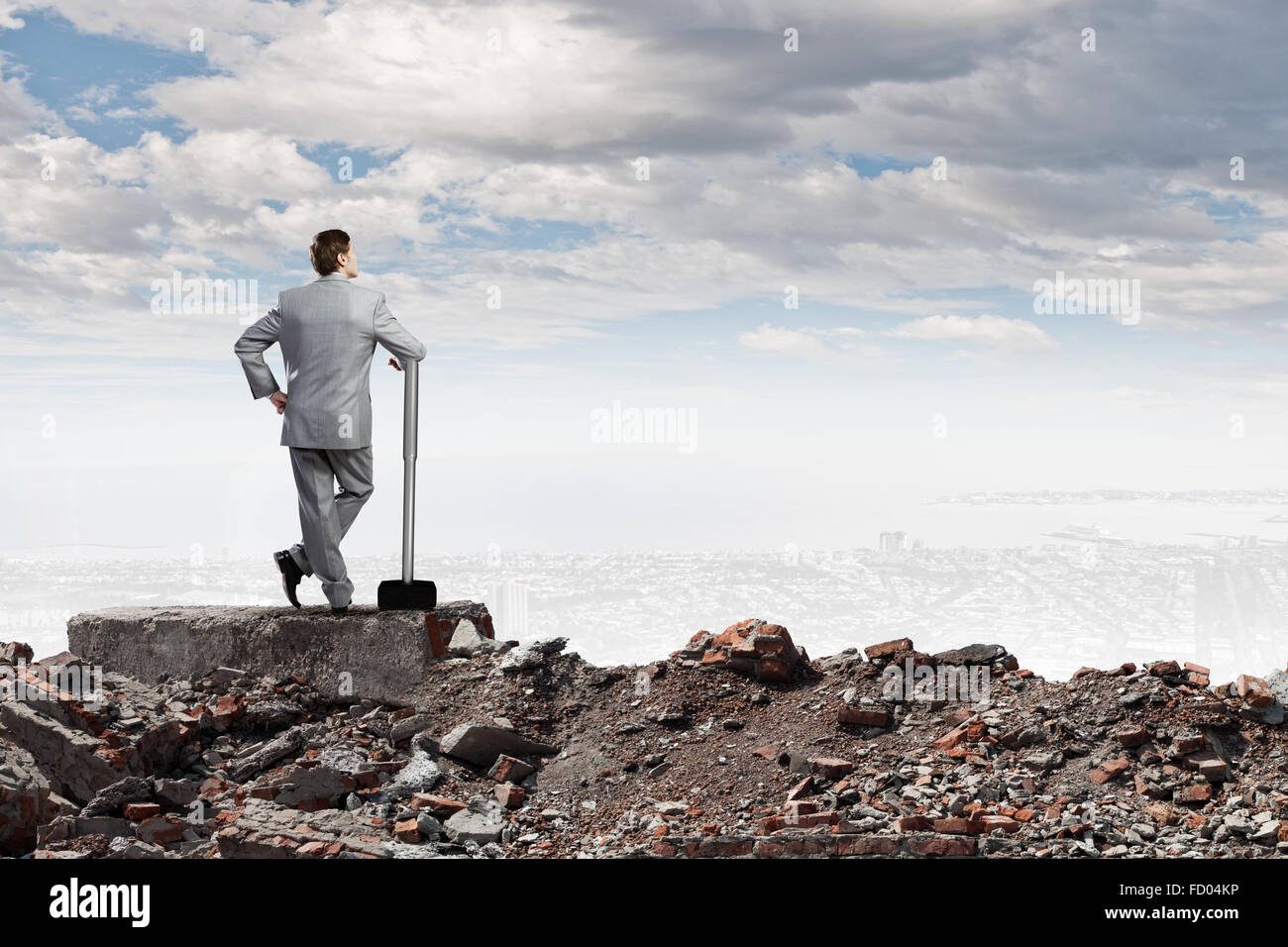 Young businessman with hammer standing on ruins Stock Photo - Alamy