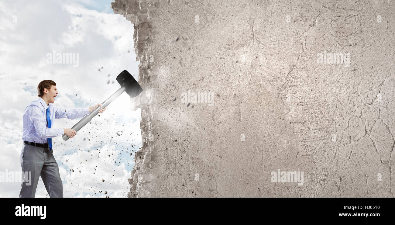 Young businessman breaking old wall with hammer Stock Photo - Alamy