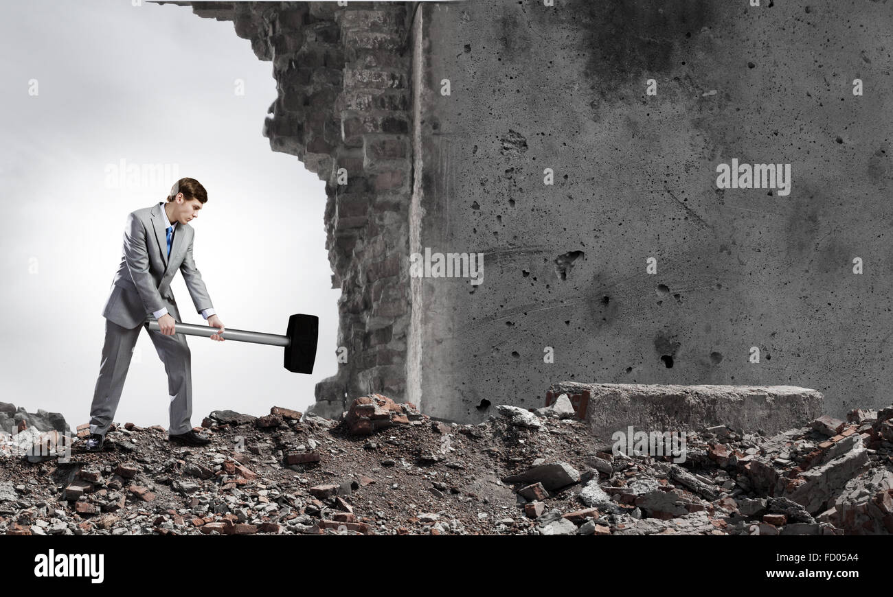 Young businessman breaking old wall with hammer Stock Photo - Alamy