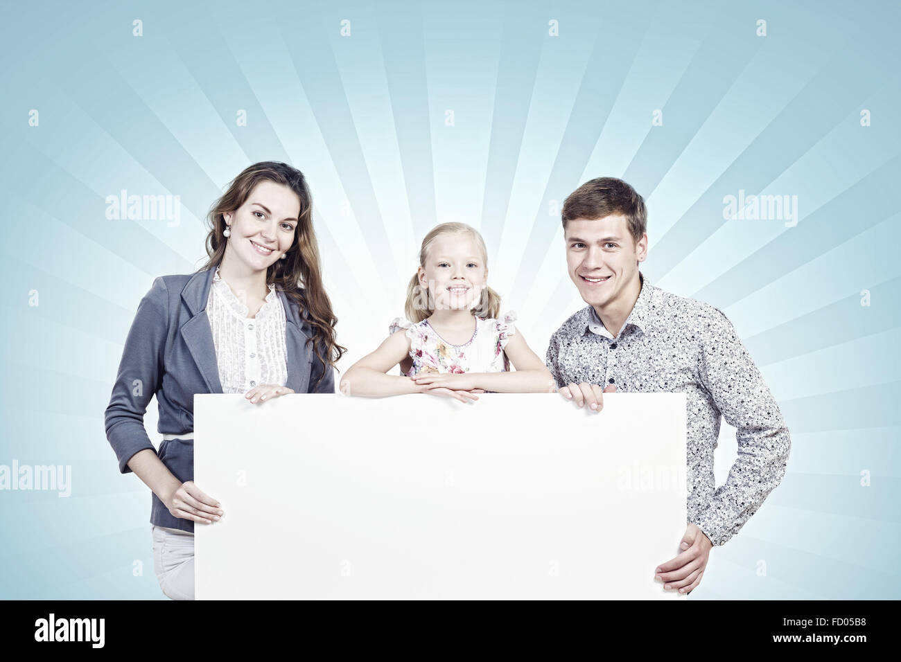 Young happy family with white blank banner. Place for text Stock Photo ...