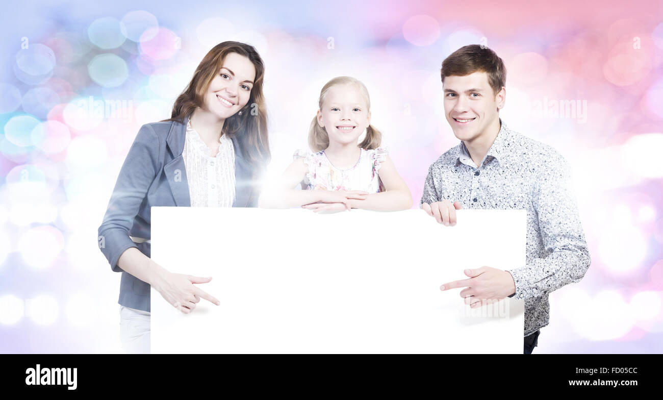 Young happy family with white blank banner. Place for text Stock Photo ...