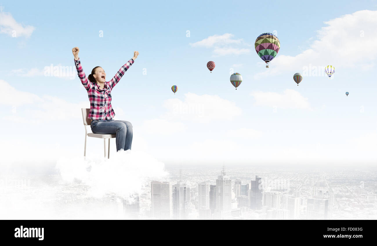 Young woman in casual with arms up celebrating success Stock Photo - Alamy