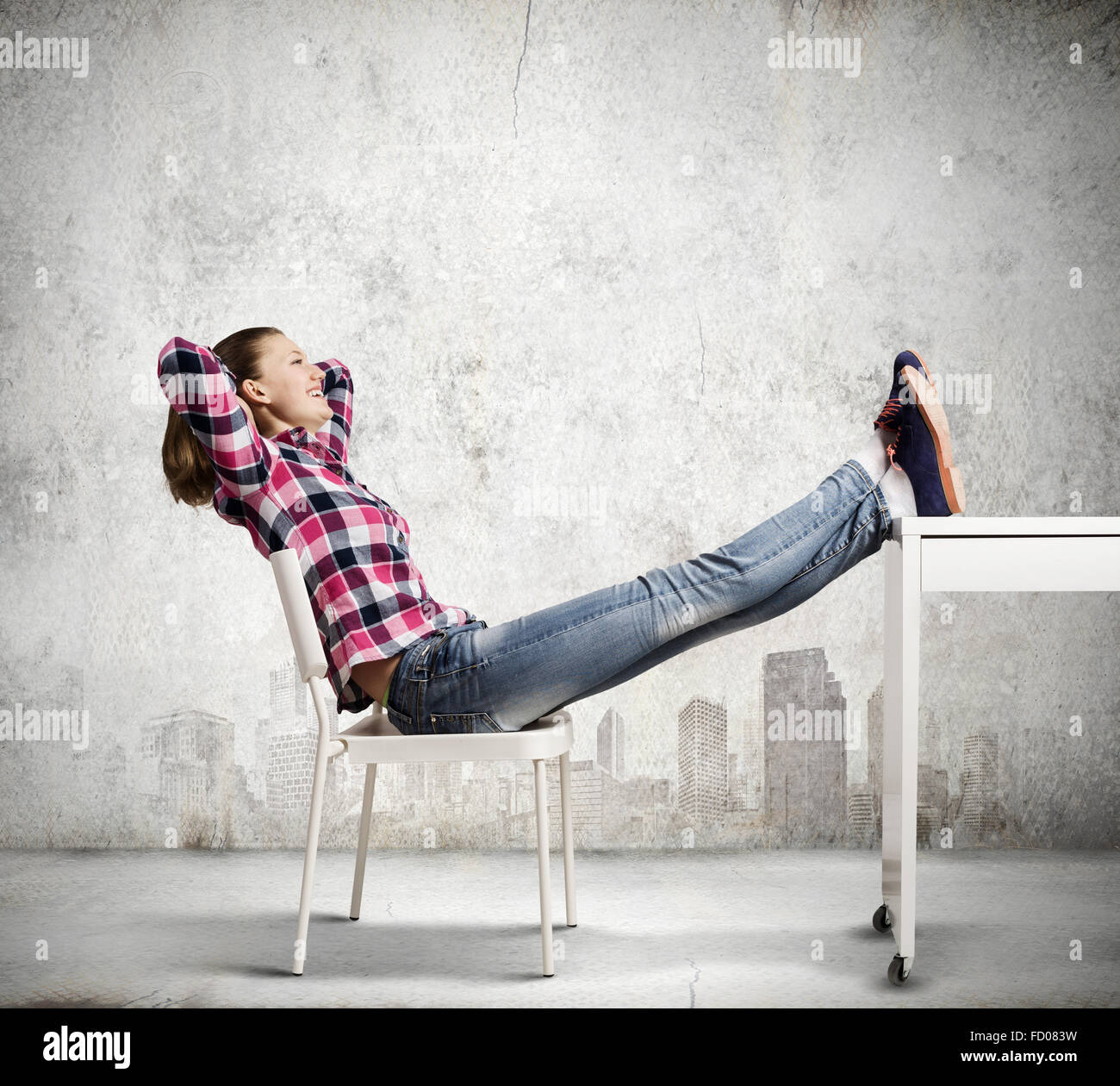 Young woman in casual with legs on table Stock Photo - Alamy