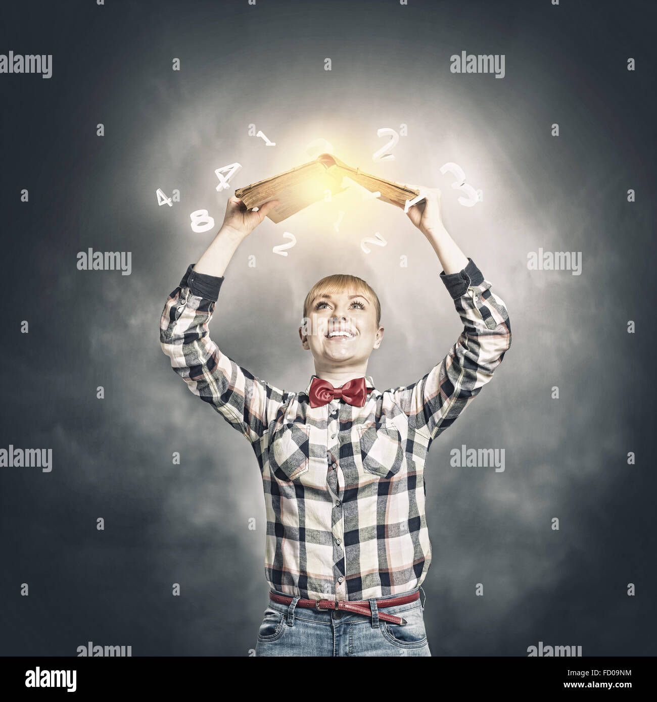 Young woman in shirt holding book above head Stock Photo - Alamy