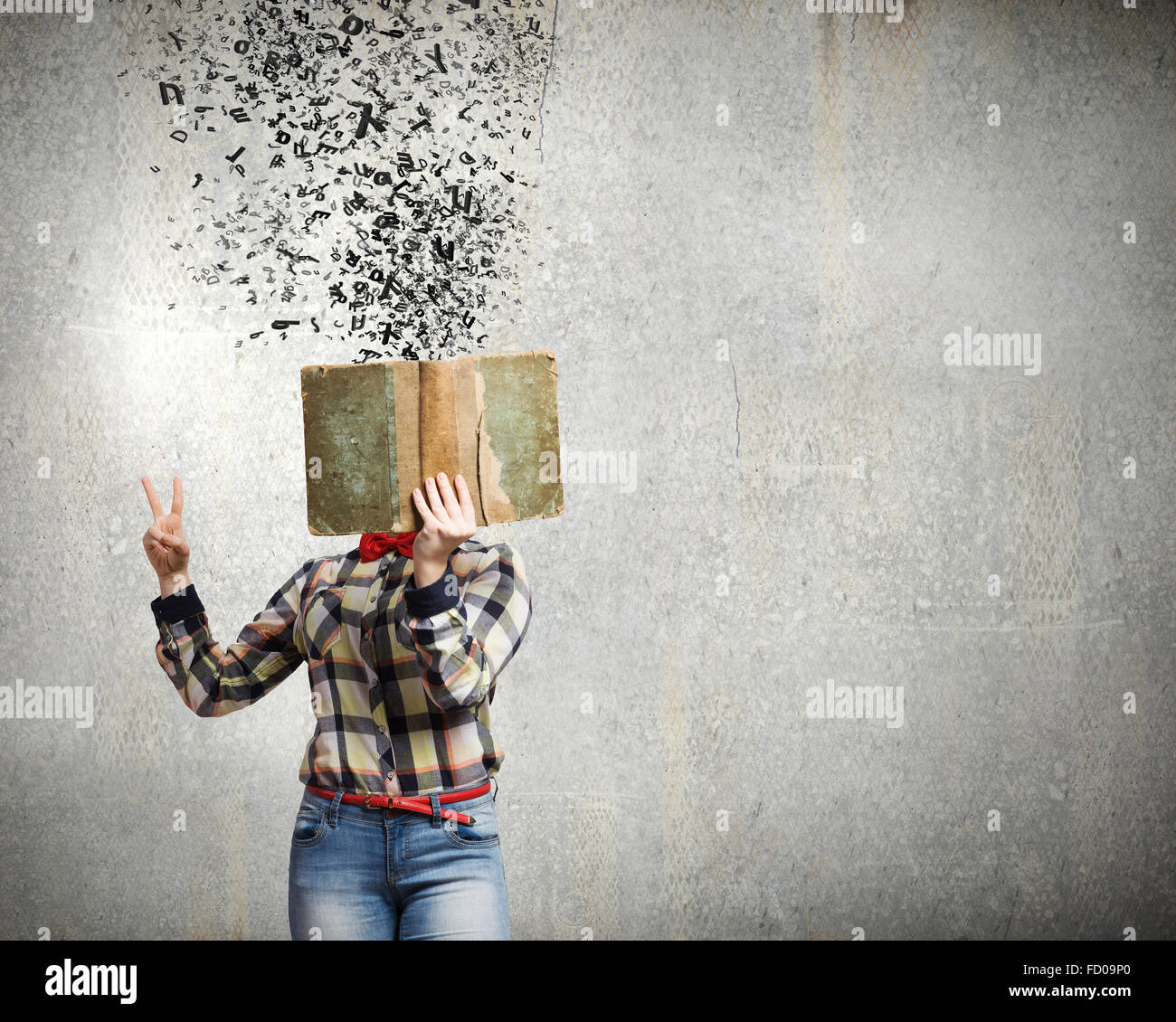Woman in casual wear hiding her face behind book Stock Photo - Alamy