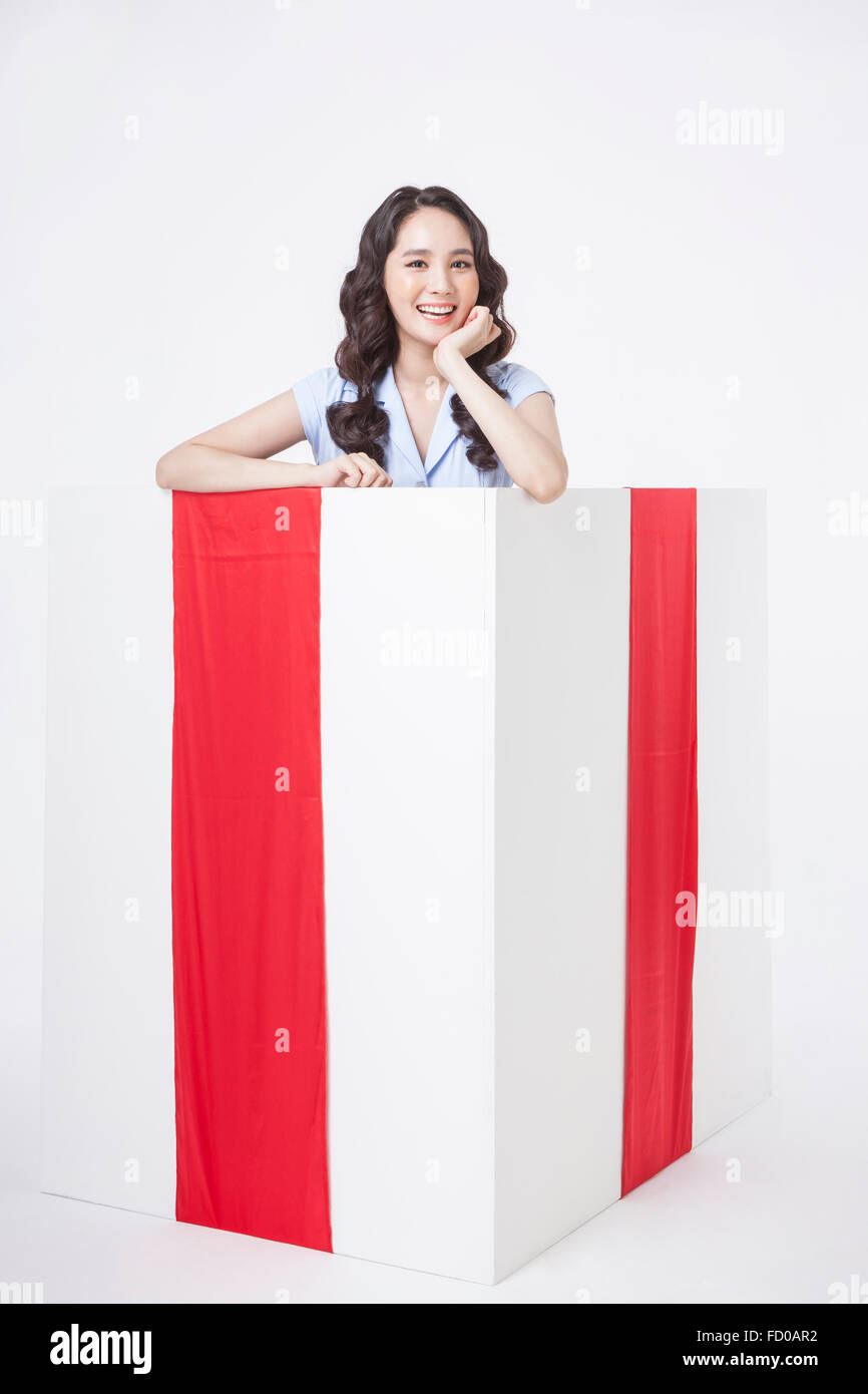 Woman in retro style placed inside of a gift box putting a hand under ...