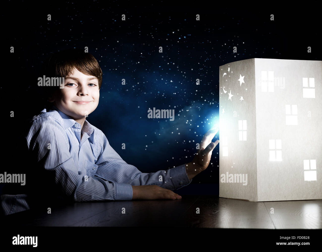 Cute little boy looking at model of house Stock Photo - Alamy