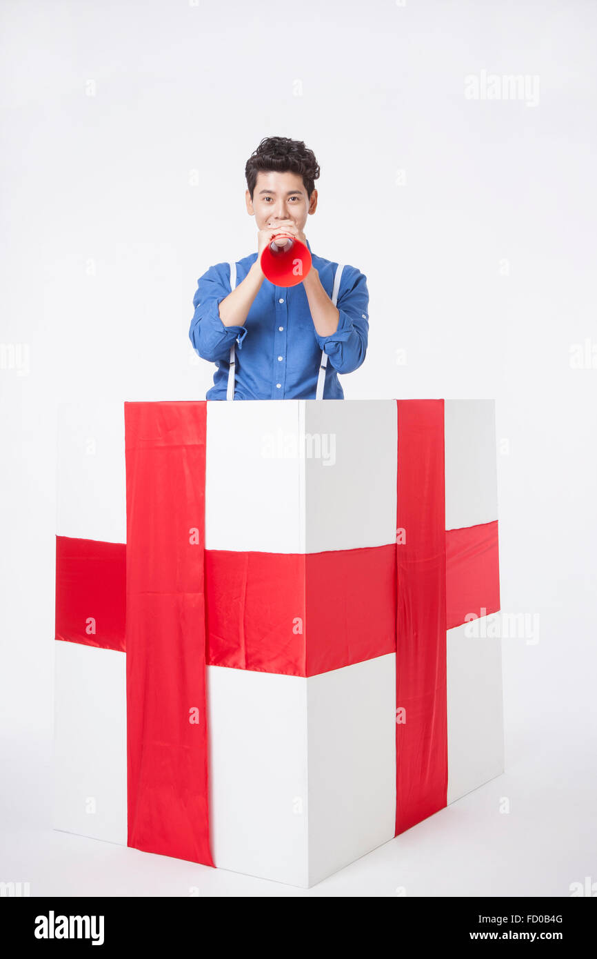 Man in blue shirt placed in a gift box staring forward and holding a ...