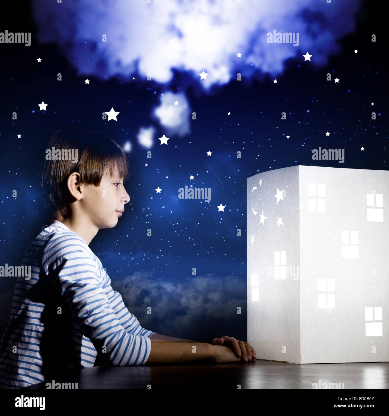 Cute little boy looking at model of house Stock Photo - Alamy