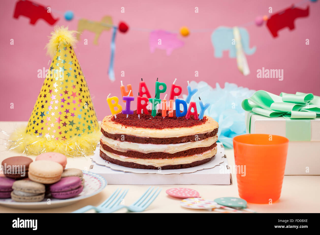 Cake with Happy Birthday candles surrounded by party related objects ...