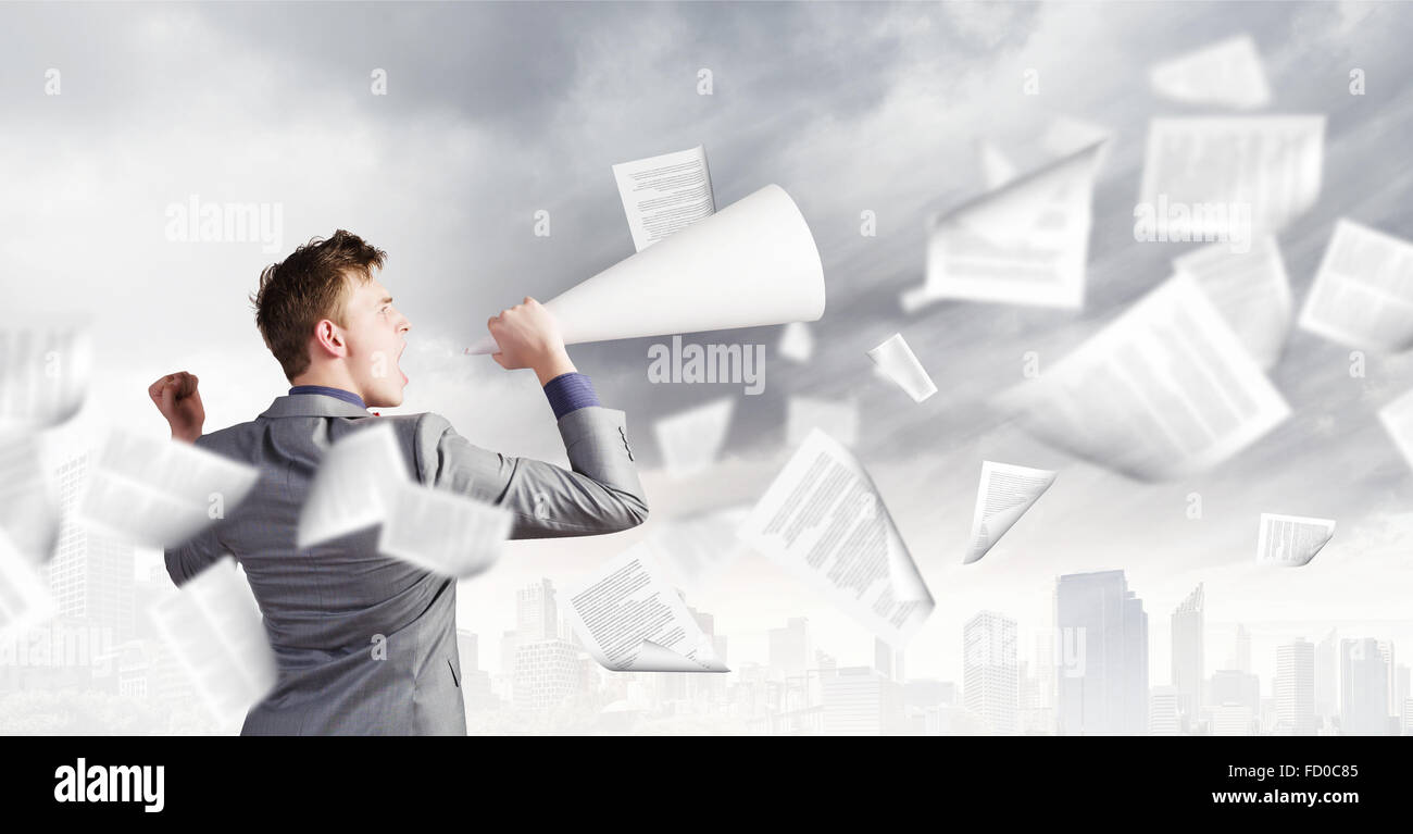 Young excited businessman screaming in paper trumpet Stock Photo - Alamy