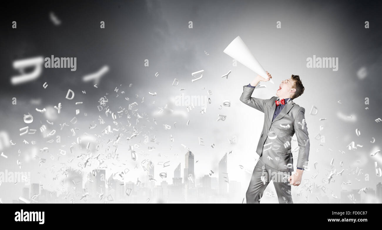 Young excited businessman screaming in paper trumpet Stock Photo - Alamy