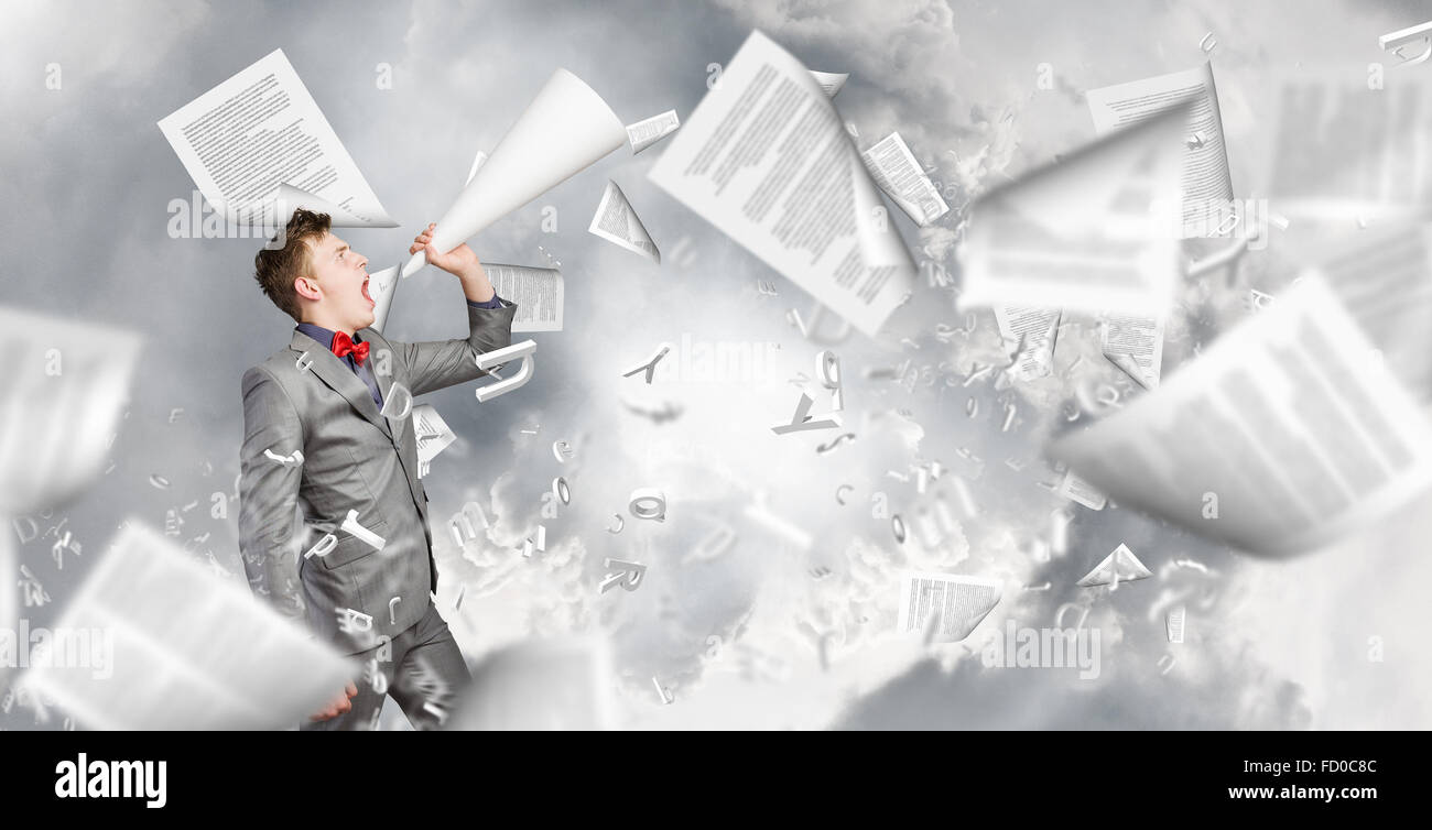 Young excited businessman screaming in paper trumpet Stock Photo - Alamy