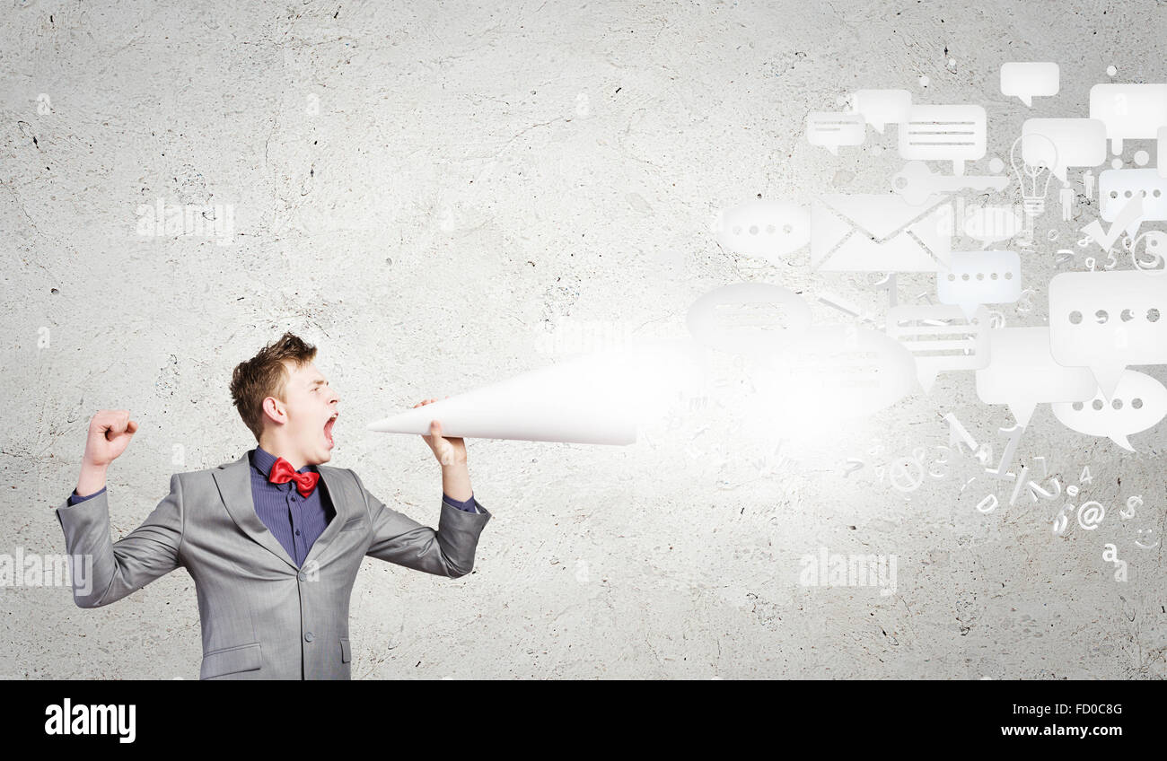 Young excited businessman screaming in paper trumpet Stock Photo - Alamy