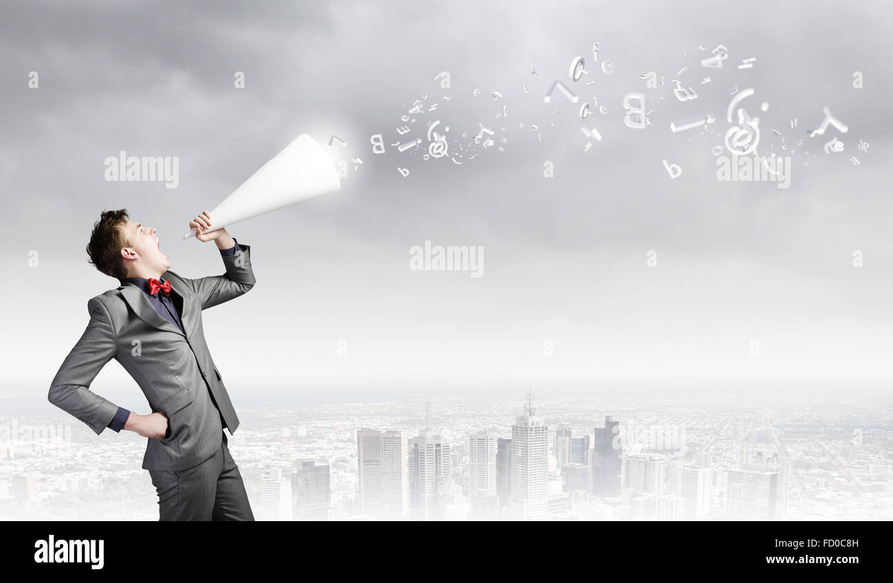 Young excited businessman screaming in paper trumpet Stock Photo - Alamy