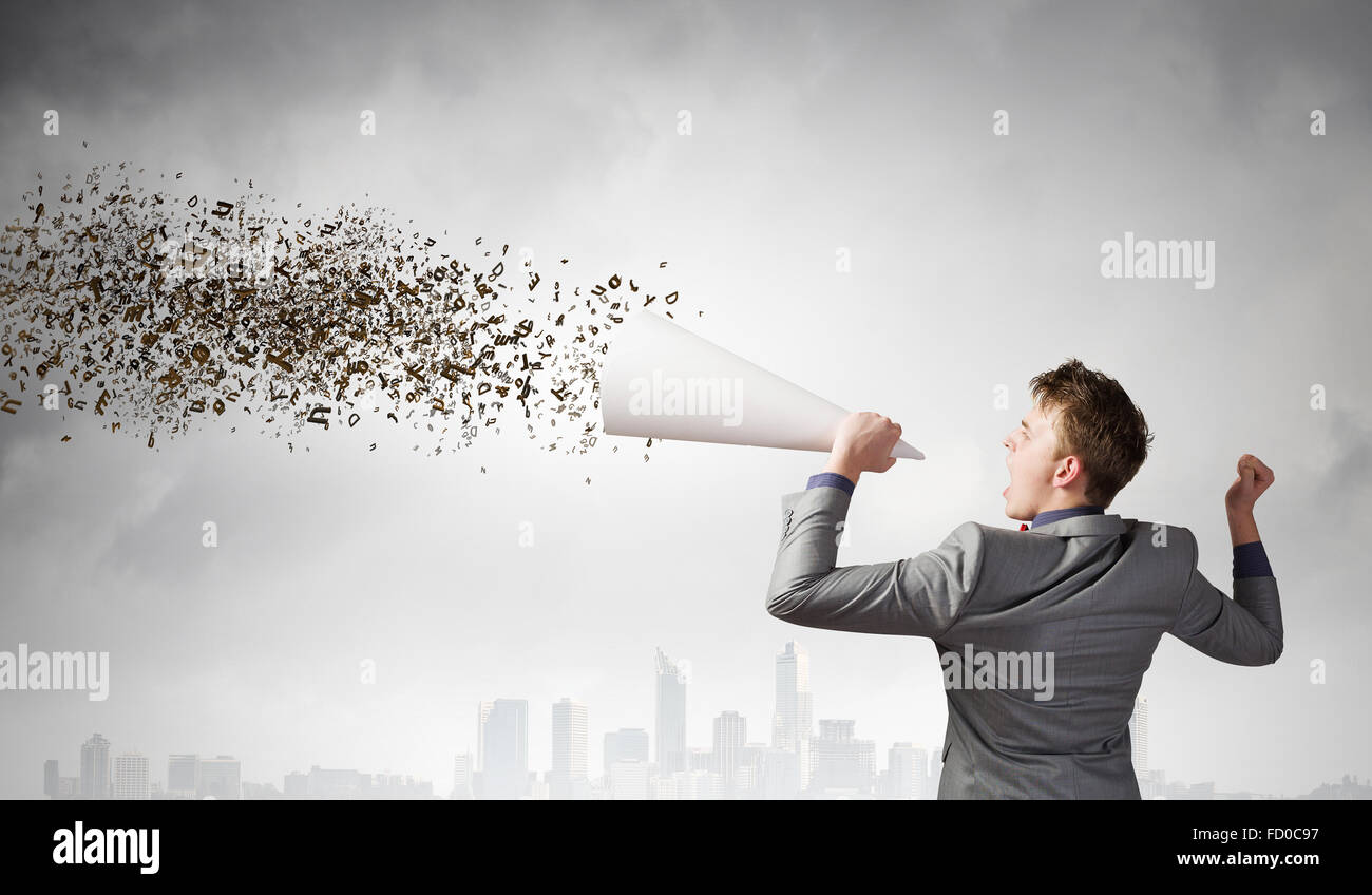 Young excited businessman screaming in paper trumpet Stock Photo - Alamy
