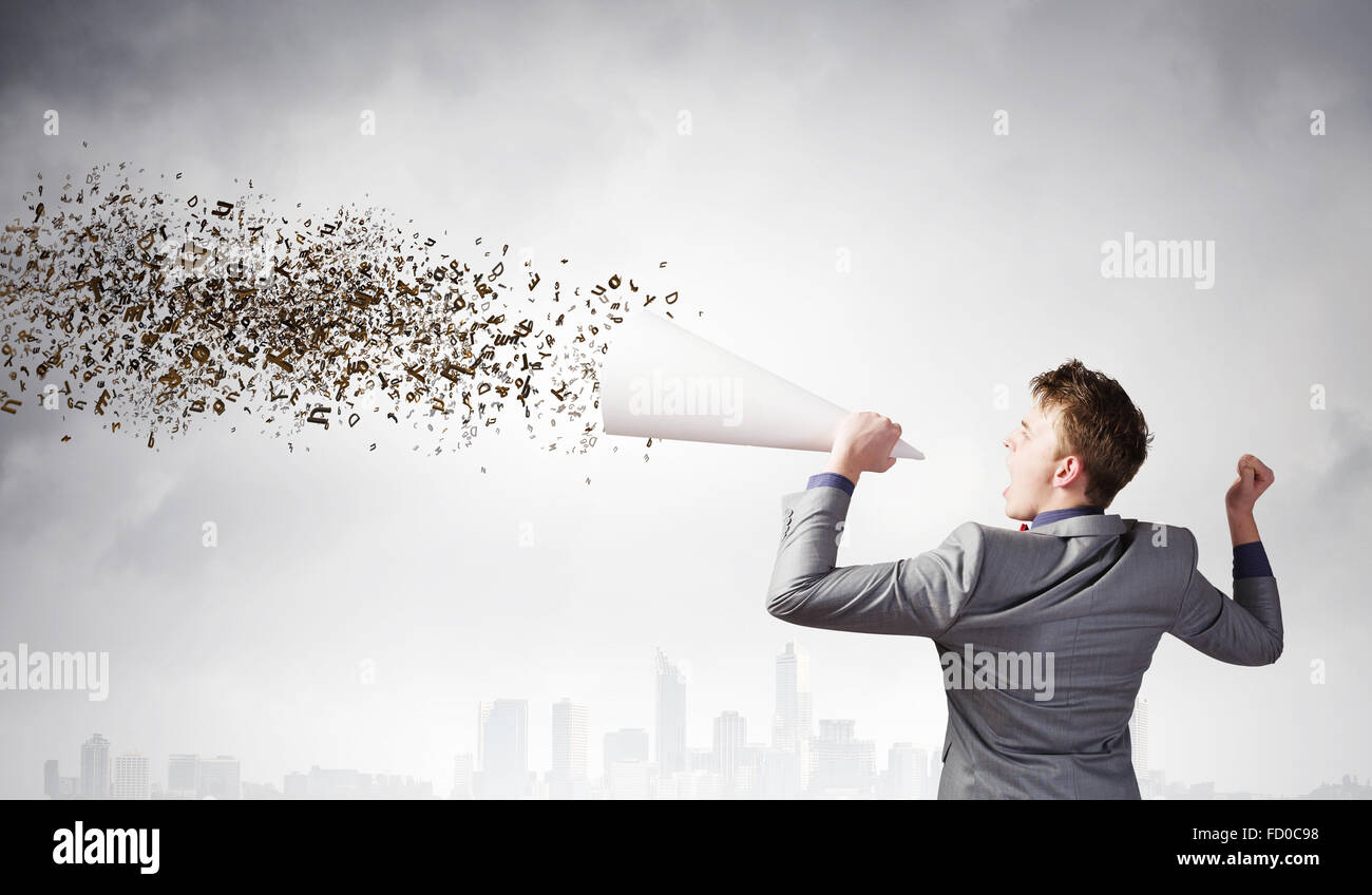 Young excited businessman screaming in paper trumpet Stock Photo - Alamy